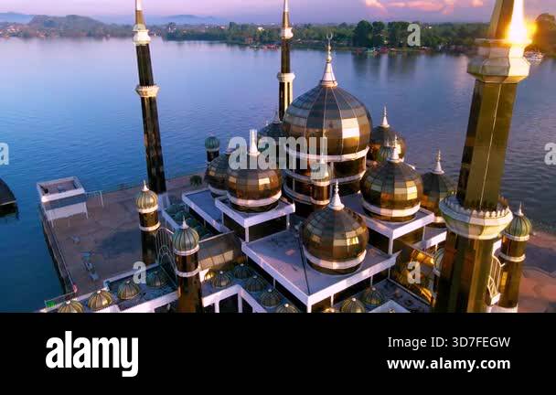 Aerial view of the Crystal Mosque at sunrise, with golden light ...