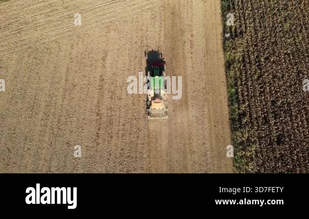 Aerial drone view of tractor planting crops with rear seeding machine ...