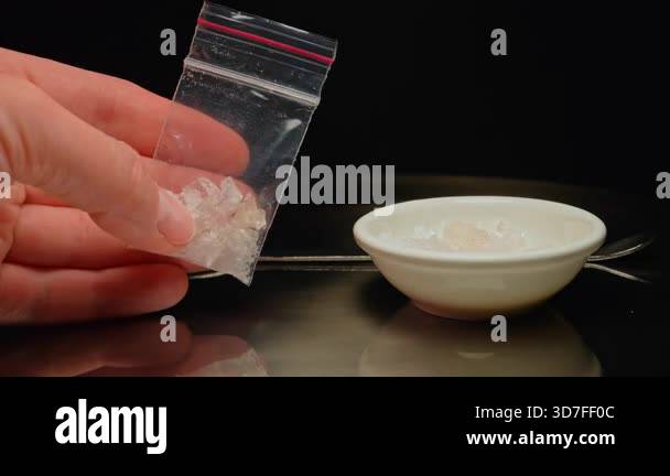 Drug dealer preparing and packaging Fentanyl Crystal meth or Crack ...