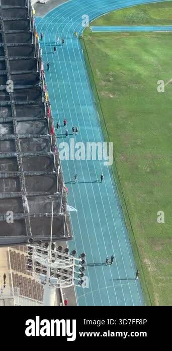 High-Angle Vertical Shot of Runners on a Blue Athletic Track with Long ...