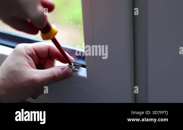 Close up of a caucasian man installing white blinds on kitchen window ...