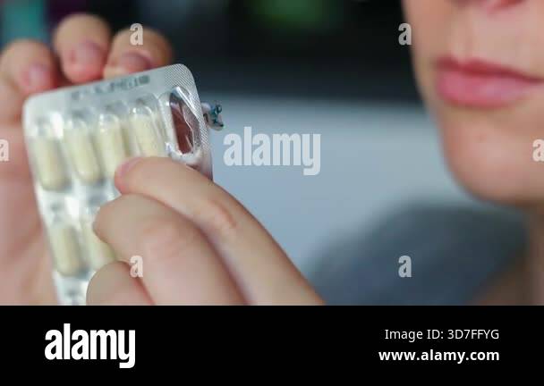 Close up of a woman taking a vitamin capsule pill out of package ...