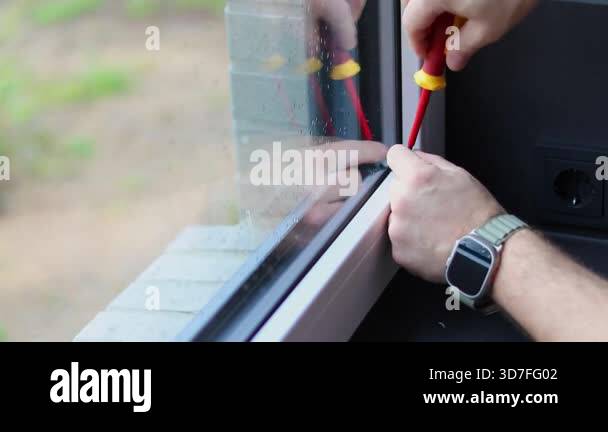 Close up of a caucasian man installing white blinds on kitchen window ...