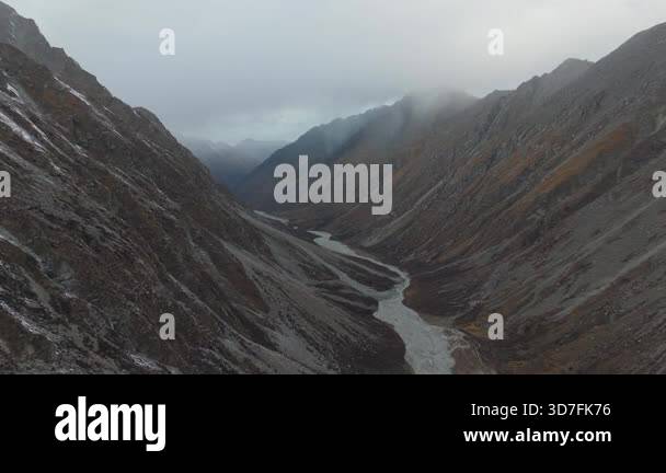 Aerial perspective captures a winding river flowing through rugged ...