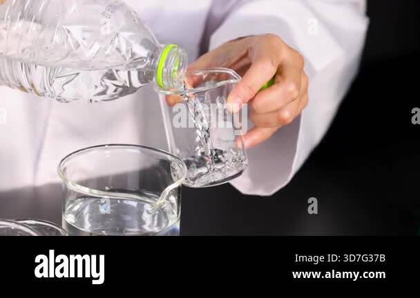 Scientist pours water into beaker with dry ice Stock Video Footage - Alamy