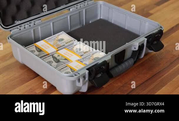 Neatly stacked bundles of dollar bills put into large briefcase ...