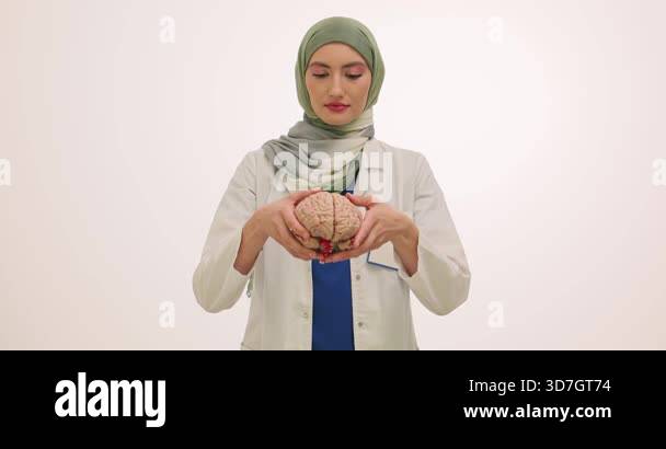 Doctor in hijab carefully separates anatomical model of brain against ...