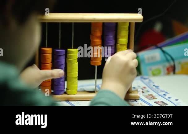 A childs hands use a colorful wooden abacus to count and learn ...