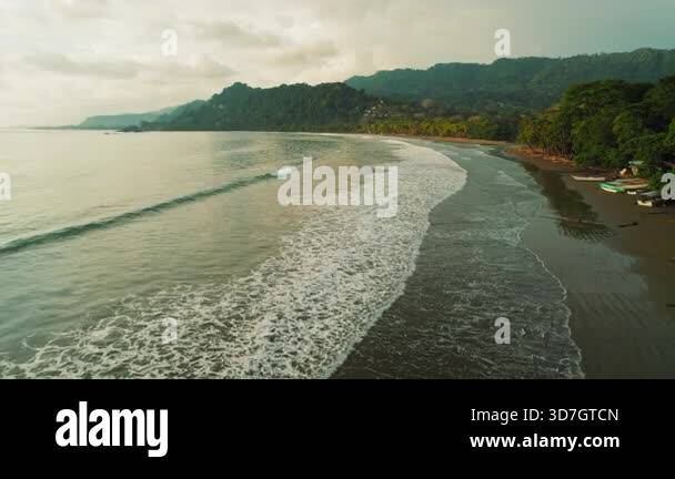 Calm ocean waves rolling at Dominicalito beach during sunset in Costa ...