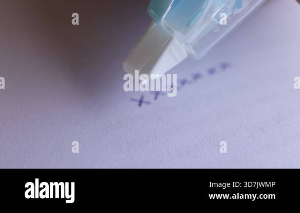 Correction tape covering blue pen marks on paper, representing editing ...