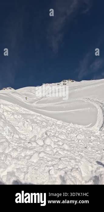 Vertical video of snowboarder carving through deep powder snow in ...