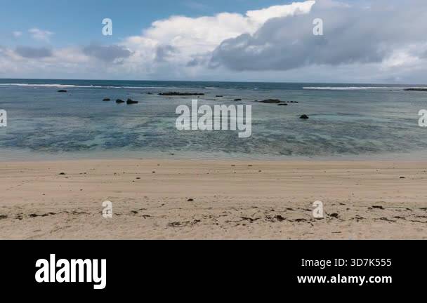 Sandy beach with shallow clear water and reef formations along the ...