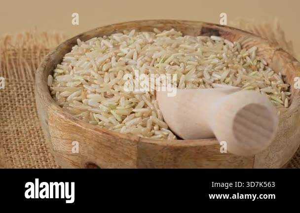 Brown rice in neutral beige background copy space. Whole spelt grain ...