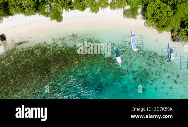 Pasandigan Cove with white beach and boats floating over the turquoise ...