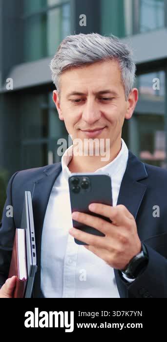 Portrait of businessman office employee using smartphone against ...