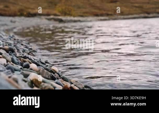 Shallow water ripples along pebble bank on cloudy day. High quality 4k ...