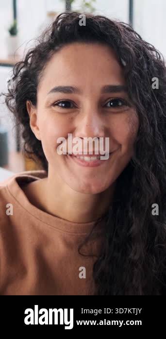 Extreme close-up portrait of happy young woman with curly hair smiling ...