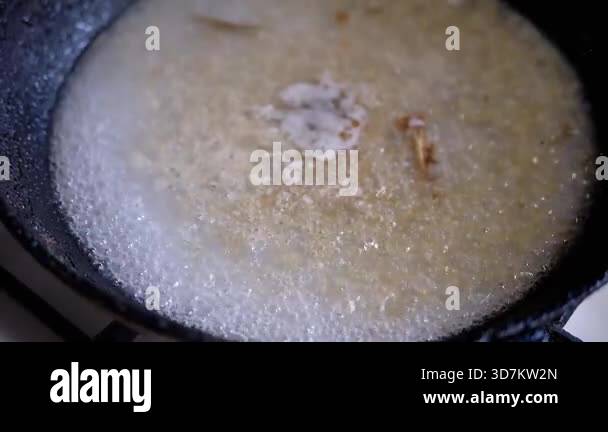 A closeup of frying oil bubbling in a pan, highlighting the cooking ...