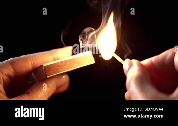 Lighting Match on Matchbox in Dark Room. Female hands lighting and ...