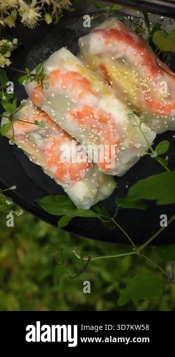 Colorful spring rolls filled with vegetables and shrimp are arranged on ...