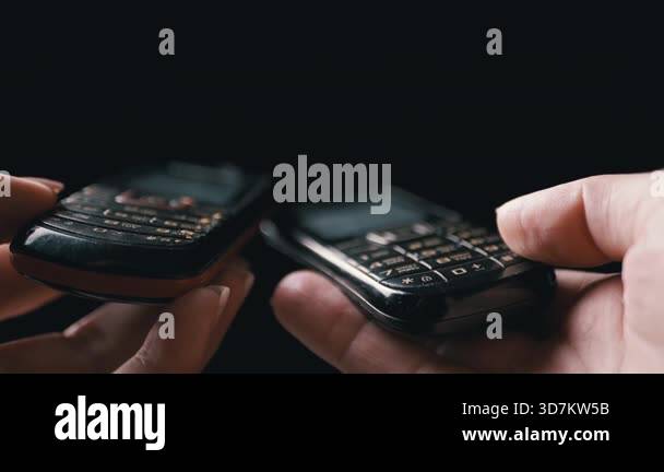 Hands gripping Two Old Push-Button Retro Mobile Phones symbolize strong ...