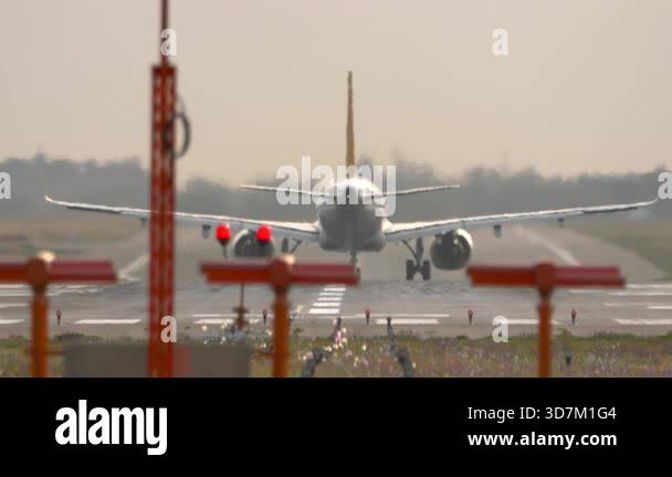 Rear view of a commercial jet airliner positioned on the runway, tail ...