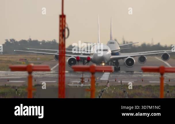 Two commercial aircraft taxiing in sequence on the runway, viewed from ...
