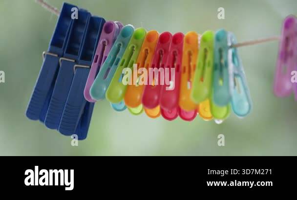 Colourful clothespins hang together on an outdoor clothesline during ...