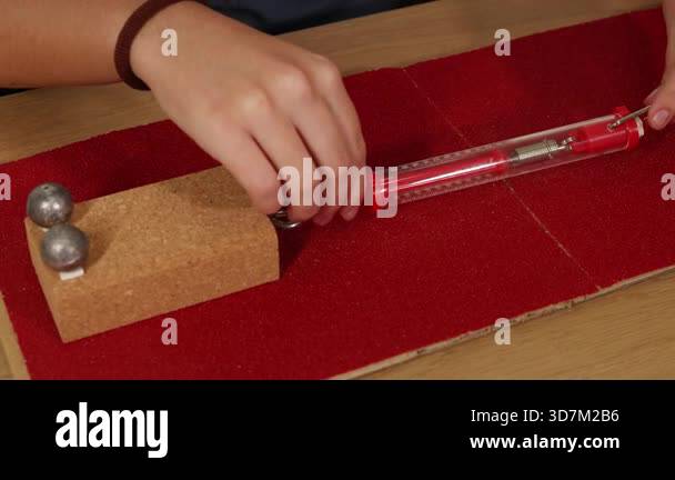 Hands use a spring scale to measure frictional force on a block with ...