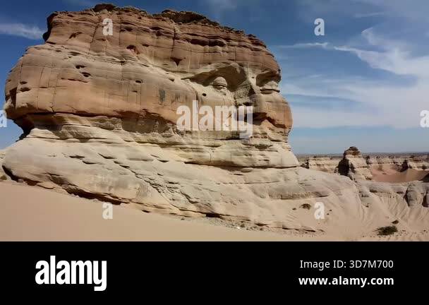 Sandstone rock formation resembling a human face in a desert landscape ...