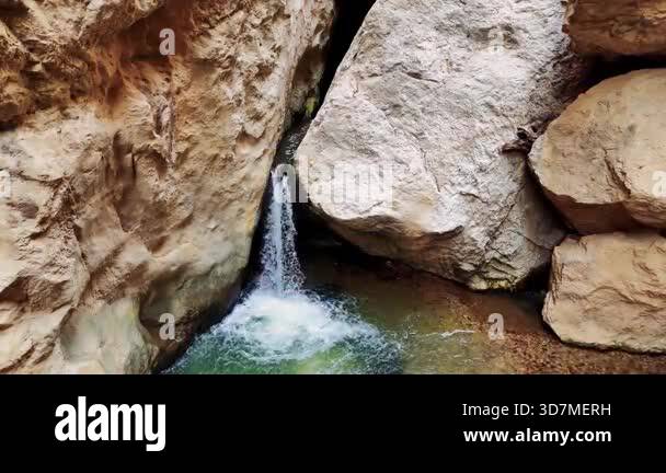 Tranquil little waterfall trickling through a narrow rocky gorge. The ...