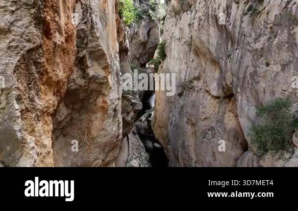 Breathtaking aerial view gliding through a narrow, rugged canyon ...