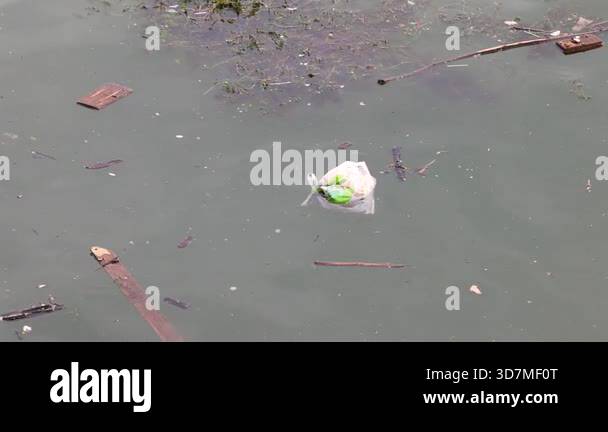 White Plastic Bag Filled With Garbage Trash Floating in Dirty Water ...
