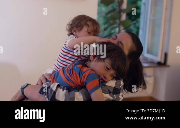 Toddler hitting and pushing older sibling while both held in mothers ...