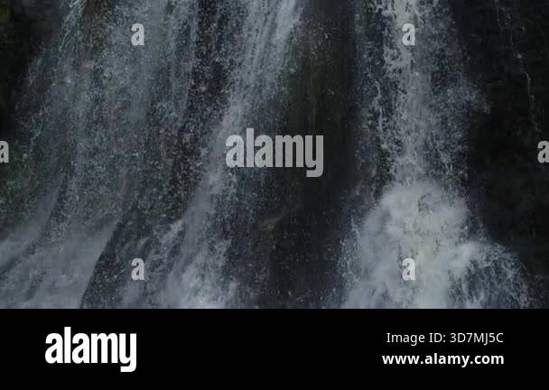 Water streaming over mossy cliffs in waterfall, filmed in ultra slow ...