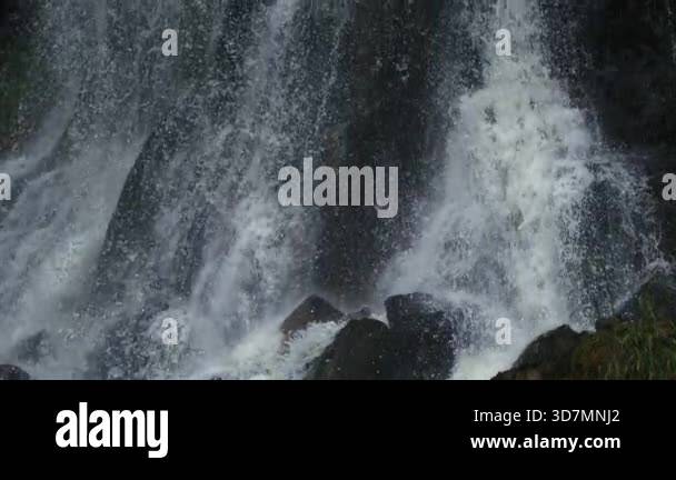 Close-up of cascading waterfall striking rock face, filmed in ultra ...