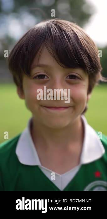 Close up portrait of young boy smiling with relaxed expression while ...