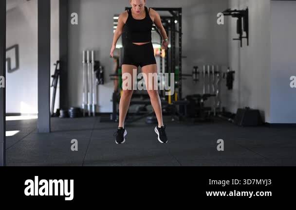 A fitness enthusiast performs squats in a well equipped gym. This session highlights proper form ...