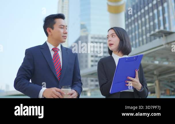 Asian manager and beautiful secretary walking and talking together ...