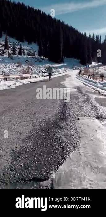 Vertical video aerial drone shot of man athlete runner on the road in ...
