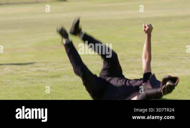 Softly rolling ball causing man diving headfirst to catch in glove ...