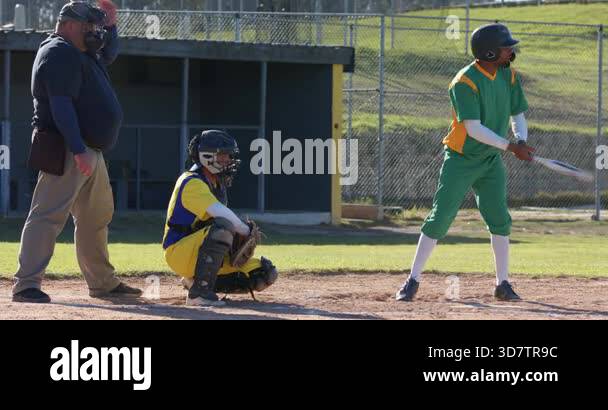 Male batter gripping bat as umpire raising hand calling strike at home ...