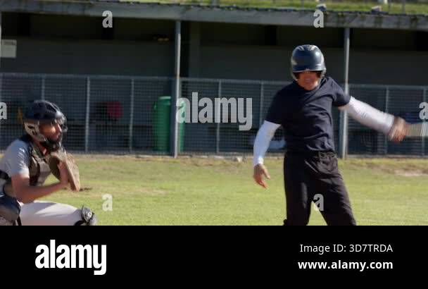 Pitcher delivering pitch, male batter swinging bat and missing ...
