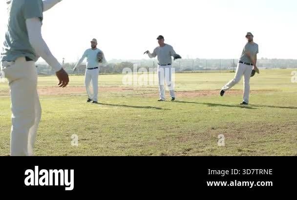 Pitching male baseball teammates practicing catch drill in outfield ...