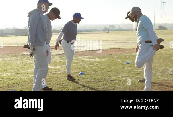Signaling coach and baseball players performing warm-up drills on grass ...
