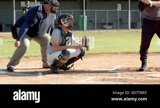 Catching incoming pitch, male catcher tossing helmet and walking to ...