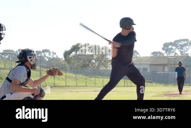 Pitcher throwing ball causing male batter swinging bat and missing ...
