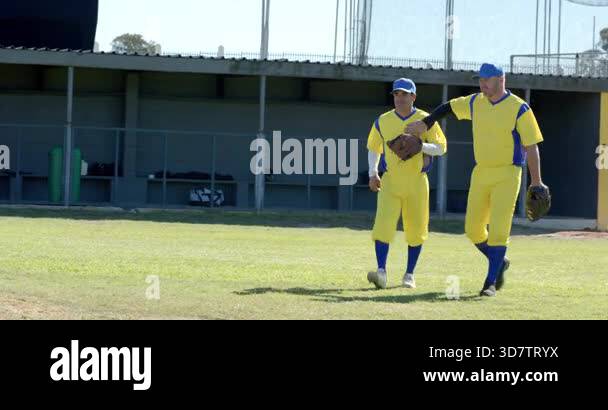 Arriving male players converging into huddle on outfield grass ...