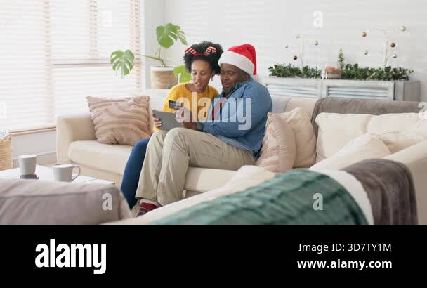 Diverse couple entering credit card number on tablet for holiday ...