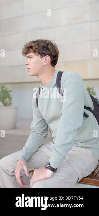 Vertical video: Man noticing someone, tilting head right and smiling ...